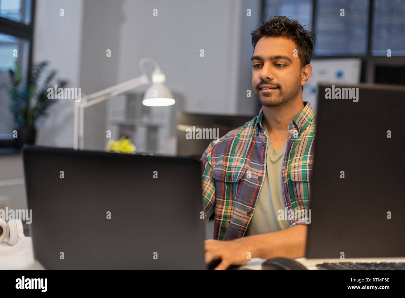 creative man with laptop working at night office Stock Photo - Alamy