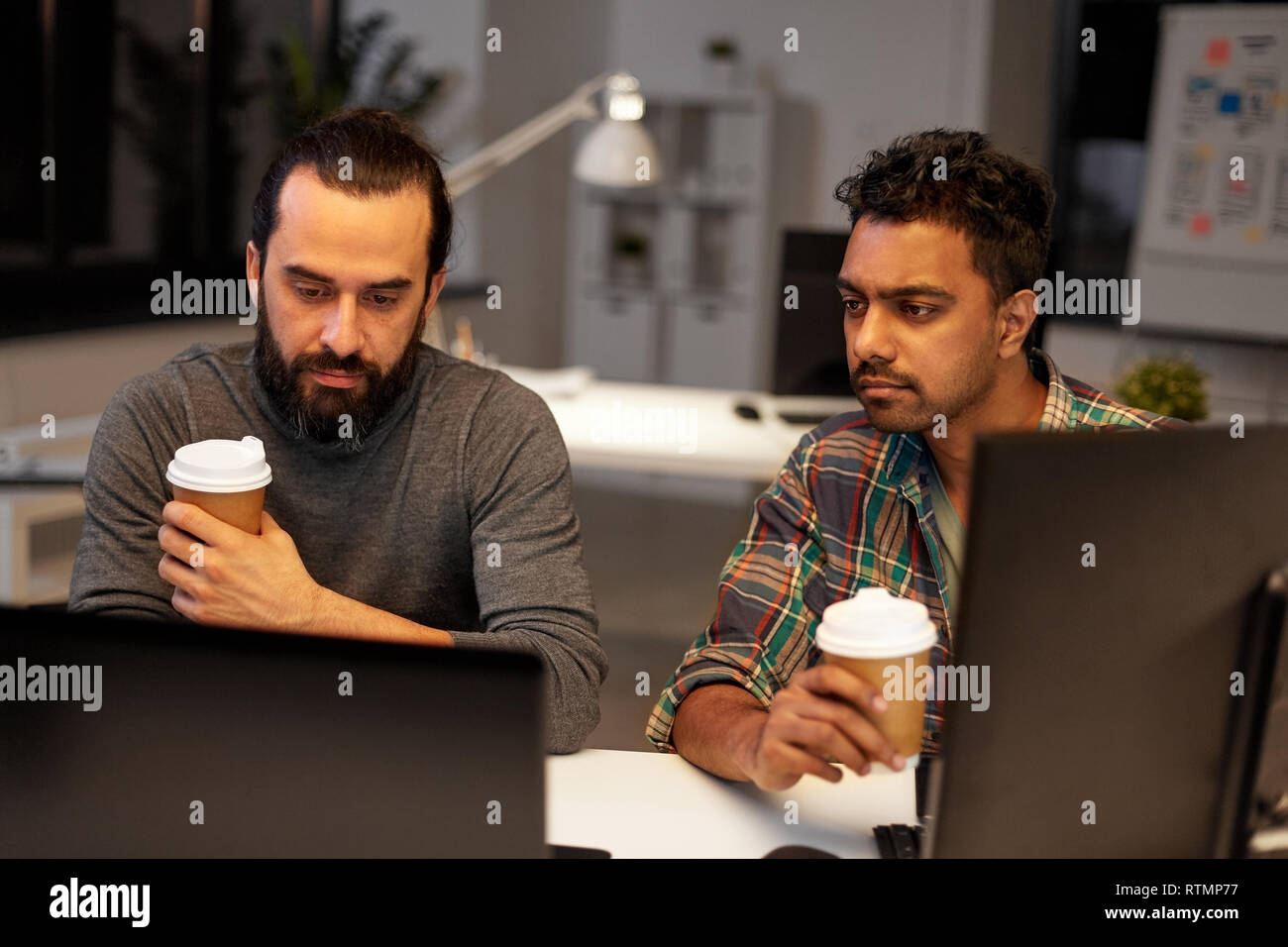 creative team drinking coffee at night office Stock Photo - Alamy