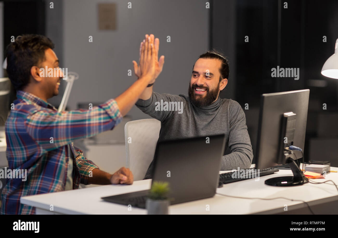creative team making high five at night office Stock Photo - Alamy