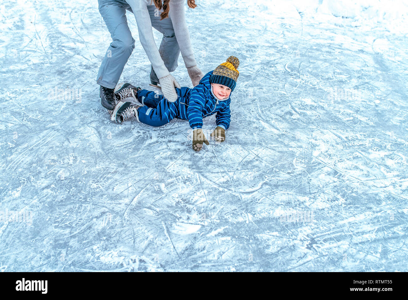 A small boy 2-5 years old, fell on the ice in the winter ice skating ...