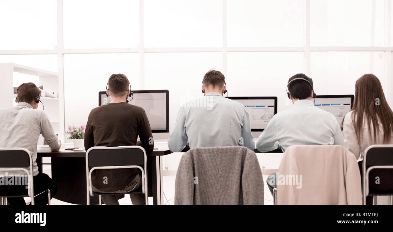 rear view.a group of call center employees sitting at the Desk Stock ...