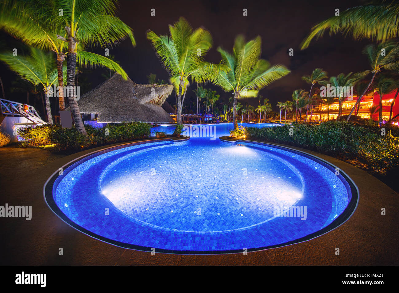 Tropical swimming pool and palm trees in luxury resort at night Stock ...
