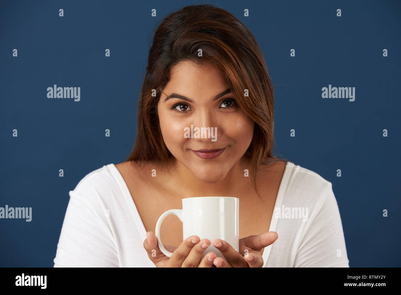 Woman check aroma of hot drink on blue studio background Stock Photo ...