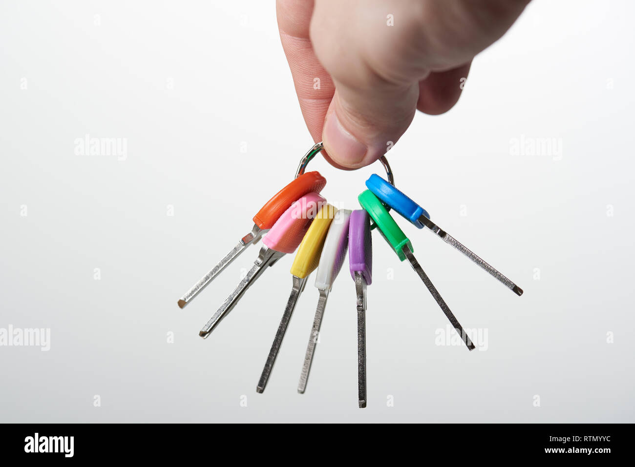 Colorful metal keys set in hand isolated close-up view Stock Photo - Alamy