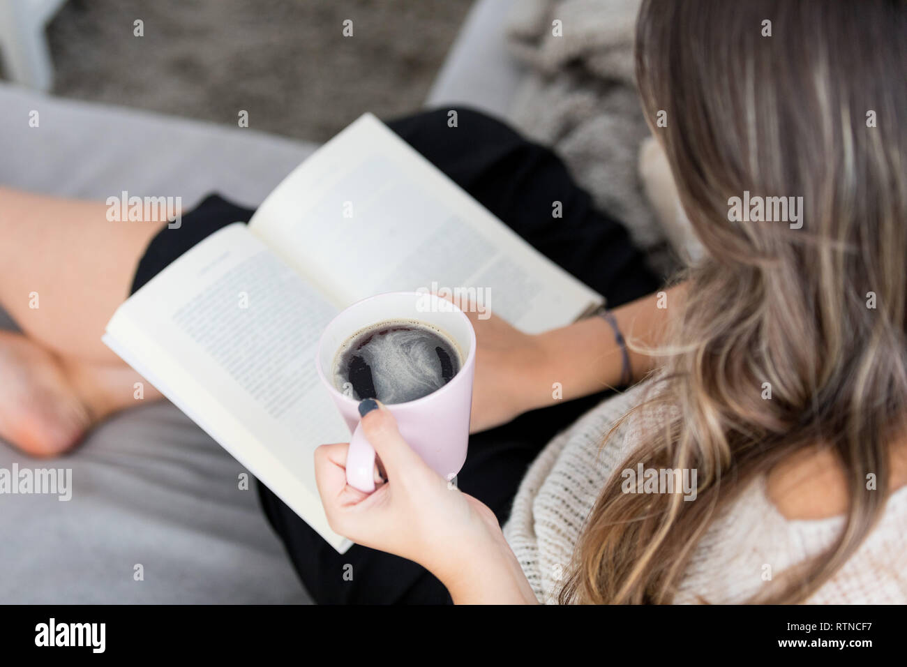 Beautiful young woman relaxing at home reading a book Stock Photo - Alamy