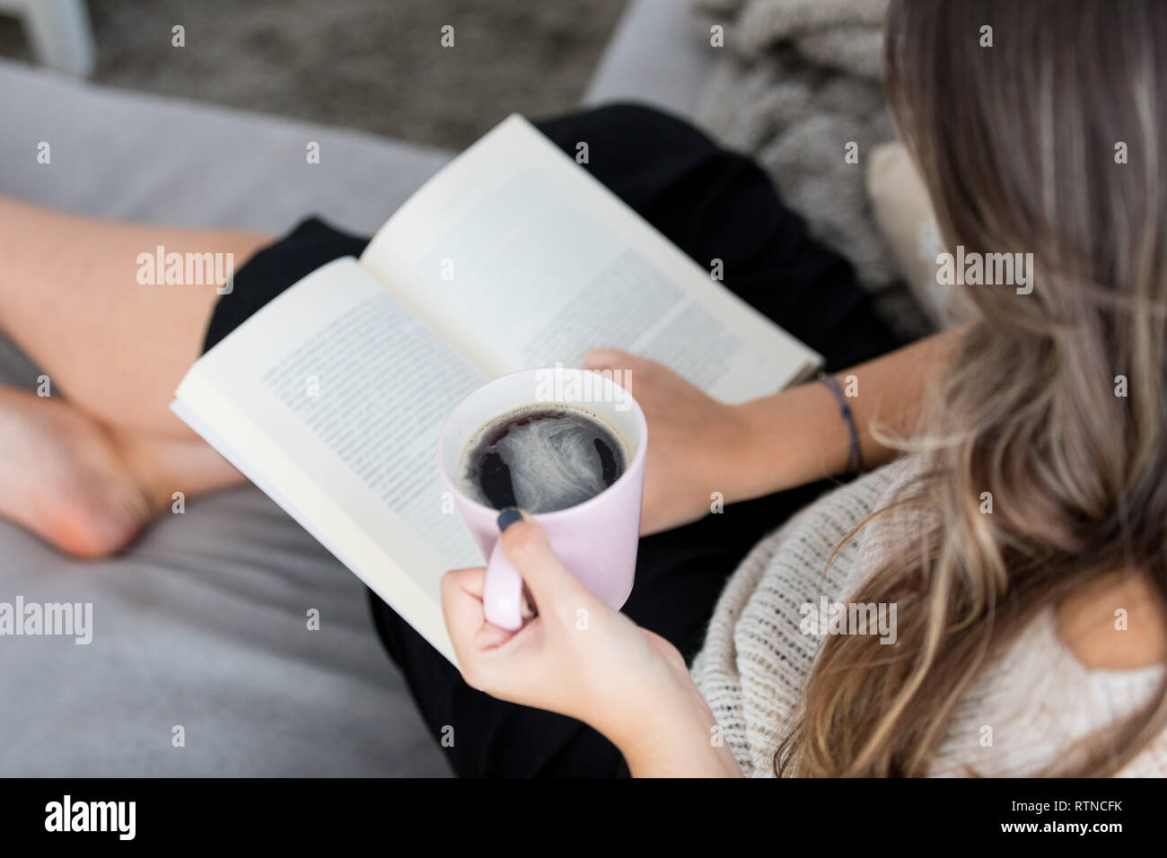 Beautiful young woman relaxing at home reading a book Stock Photo - Alamy