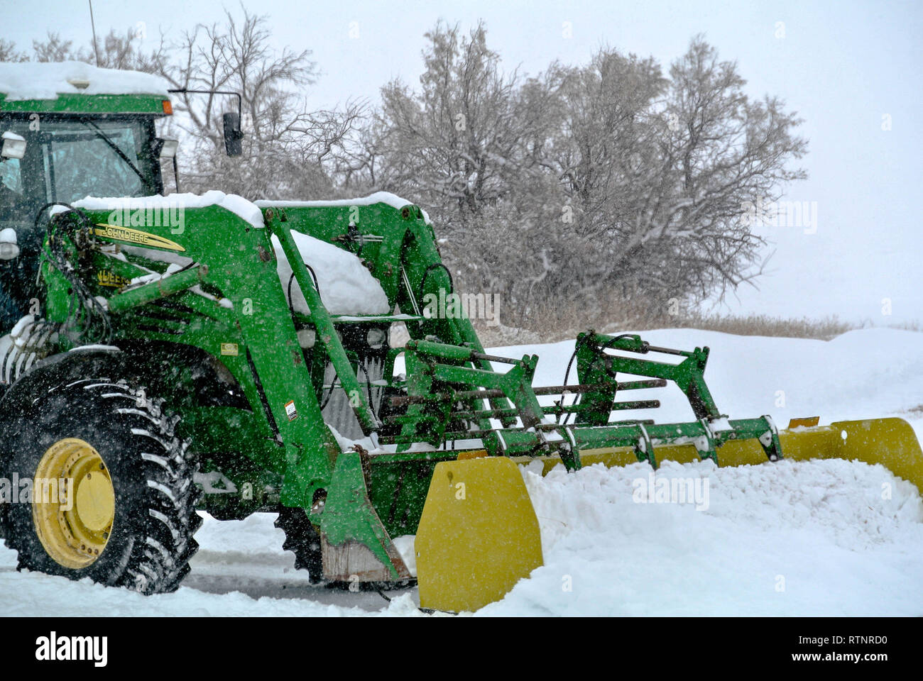 John Deere pushing snow on a farm in Montana Stock Photo - Alamy