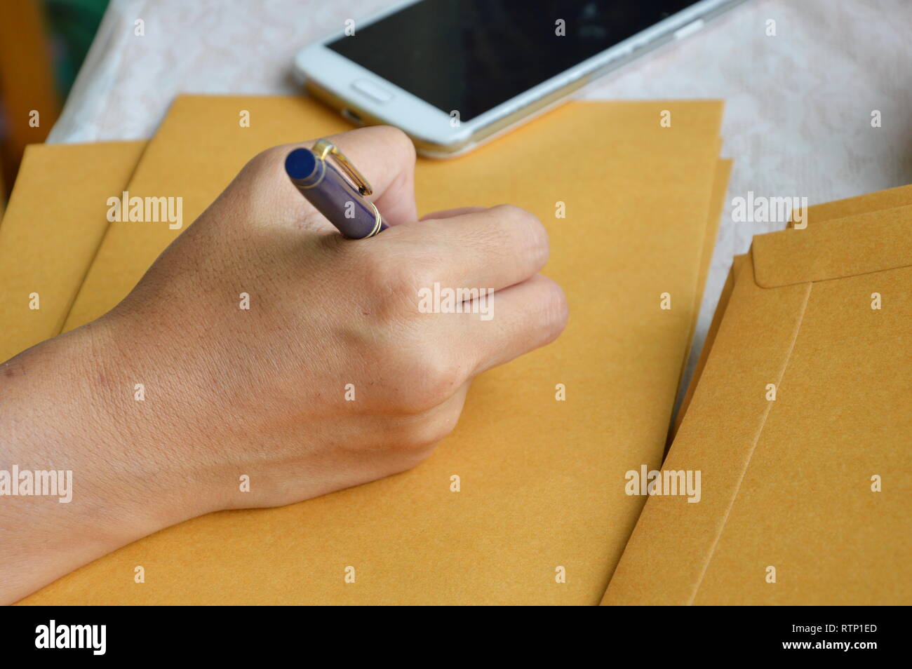 hand writing outside address on brown envelope Stock Photo - Alamy