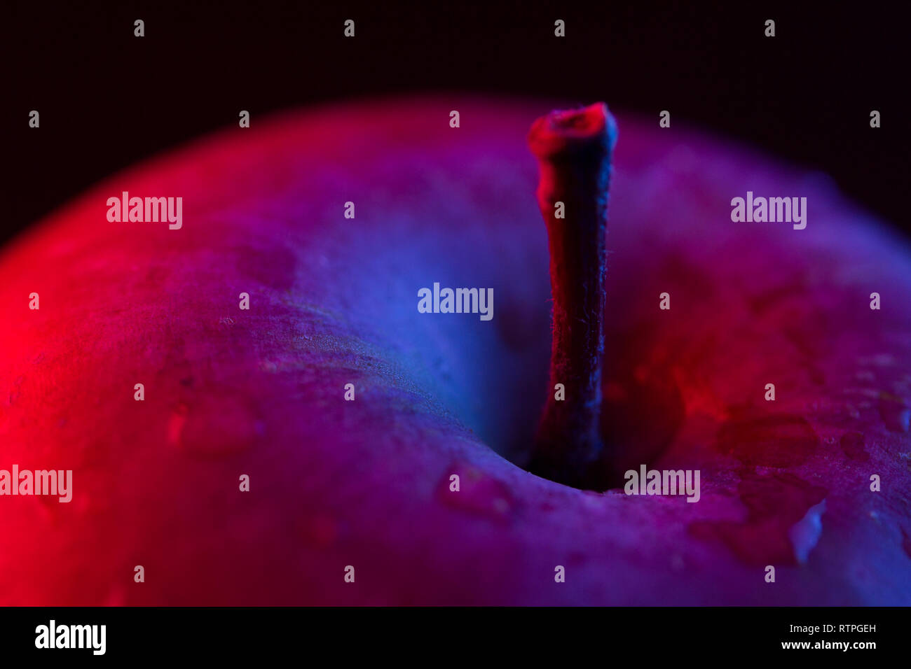 One apple on the table. Neon light. close up Stock Photo - Alamy