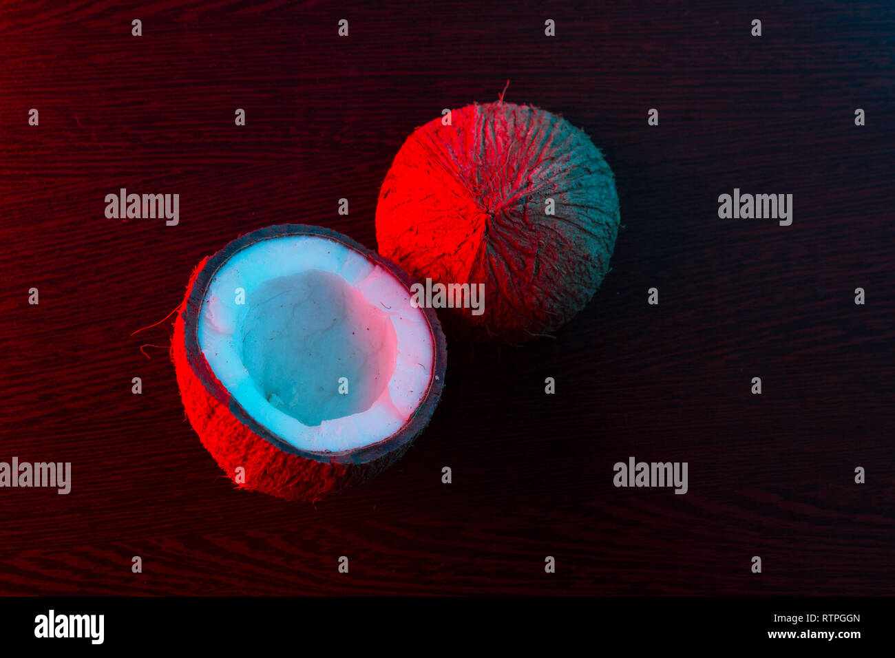 coconut in red and blue light. dark background Stock Photo - Alamy