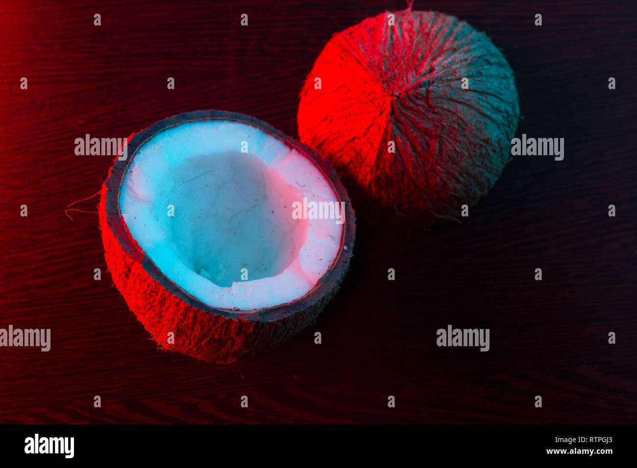 coconut in red and blue light. dark background Stock Photo - Alamy
