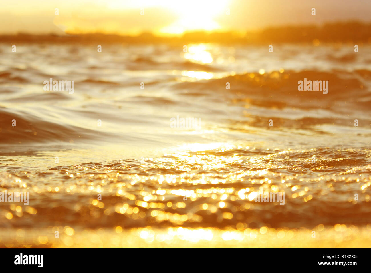 sunset in the water. waves warm orange color Stock Photo - Alamy