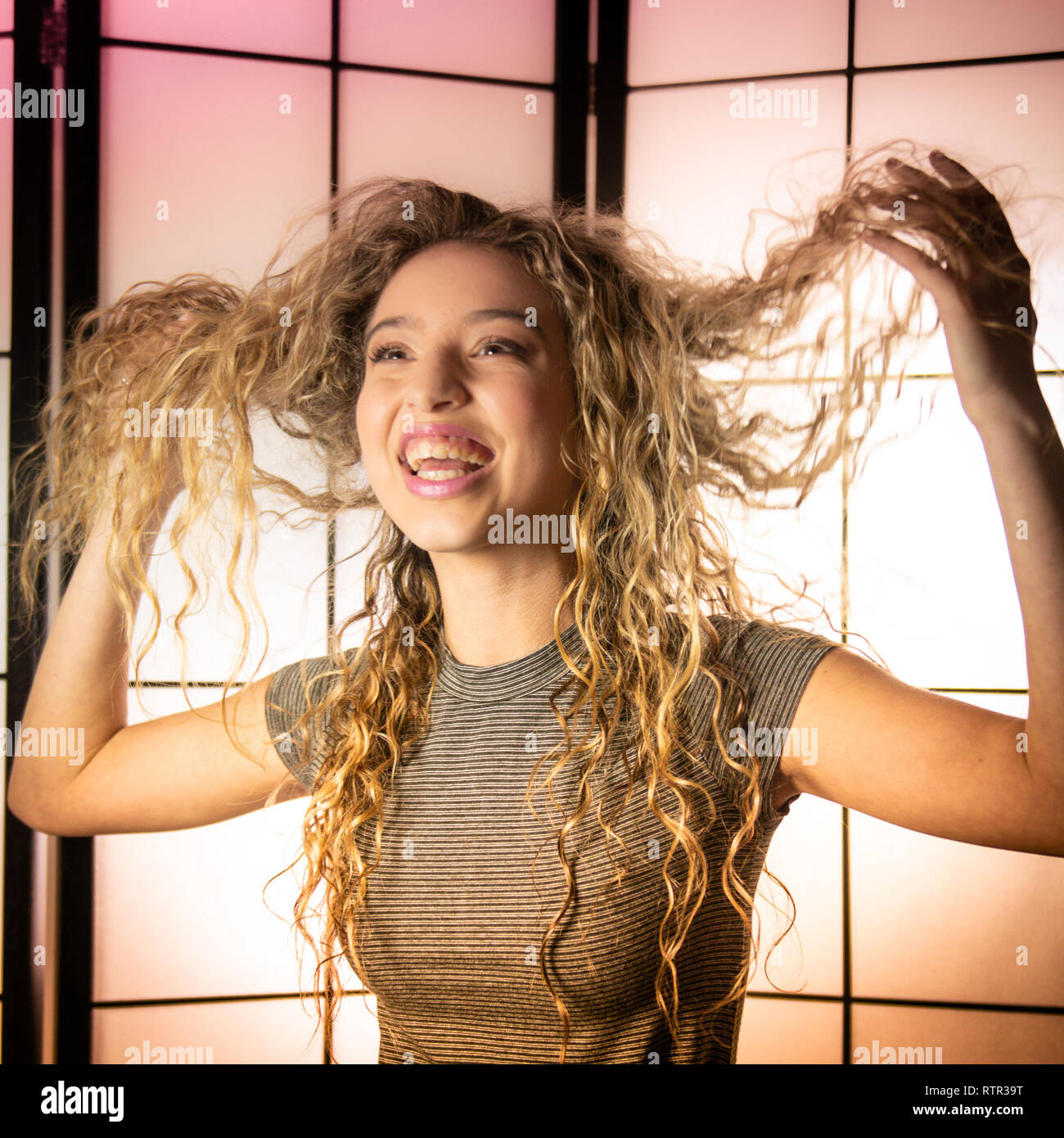 A young girl is raising her hairs with amusement Stock Photo - Alamy