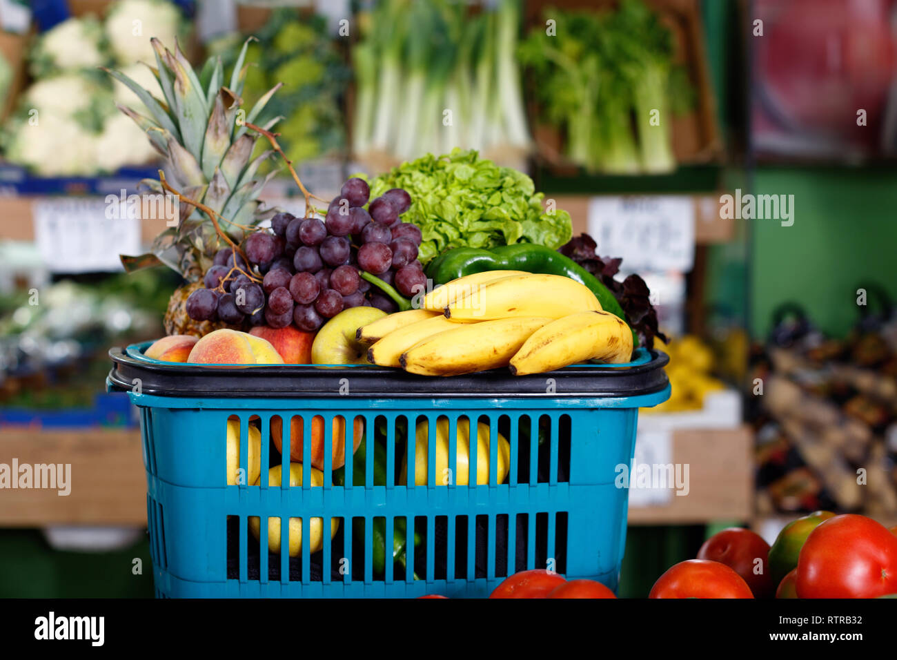 Shopping basket filled with fresh fruits and vegetables on background ...