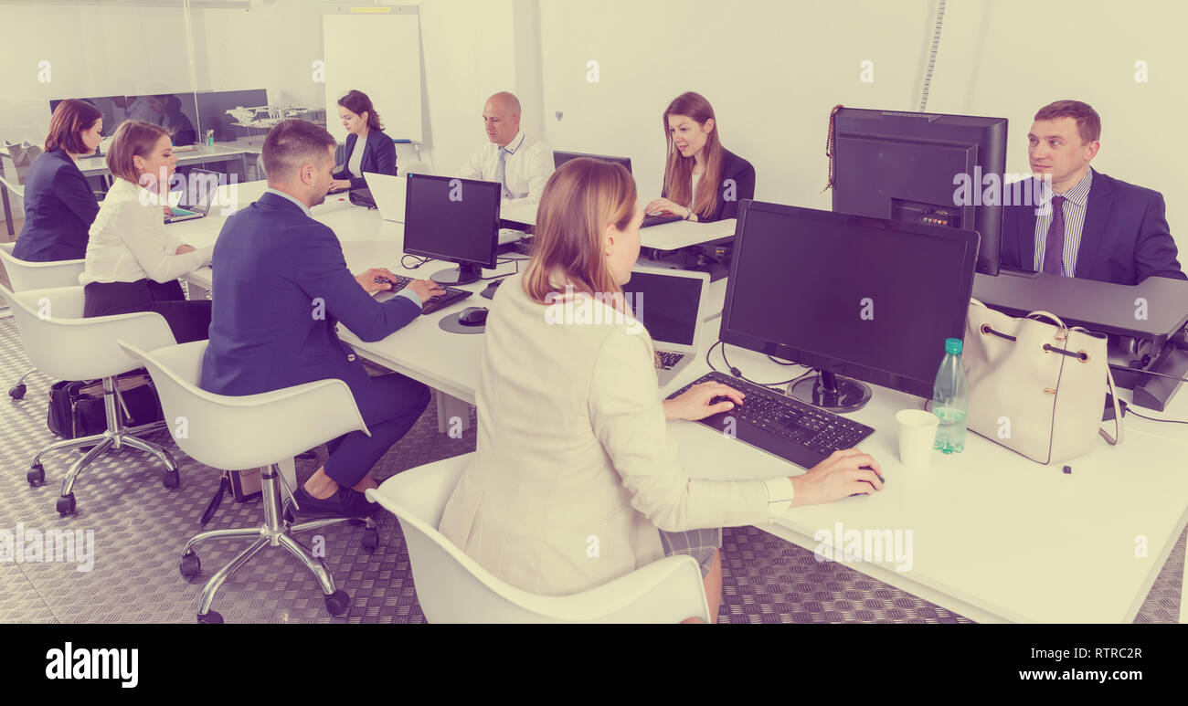 Successful coworkers engaged in business activities in busy open plan ...