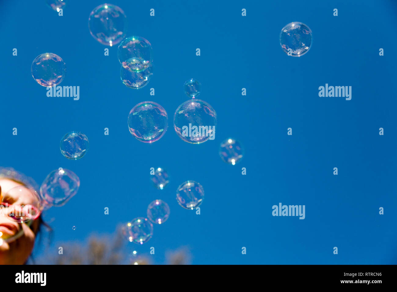 woman blowing bubbles over the blue sky Stock Photo - Alamy