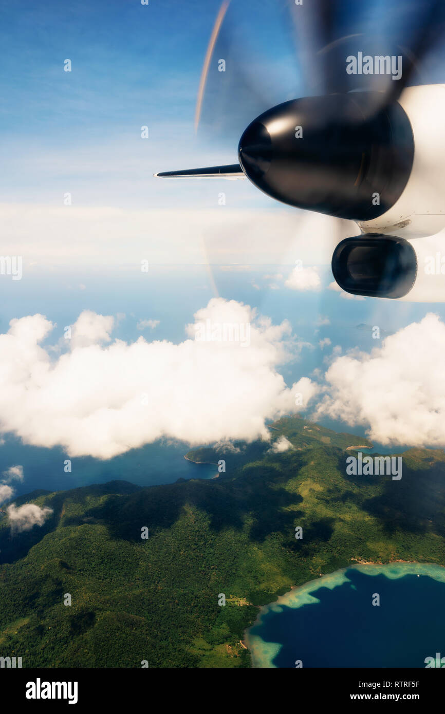 Propeller aircraft wing over tropical islands. Aerial view of airplane ...