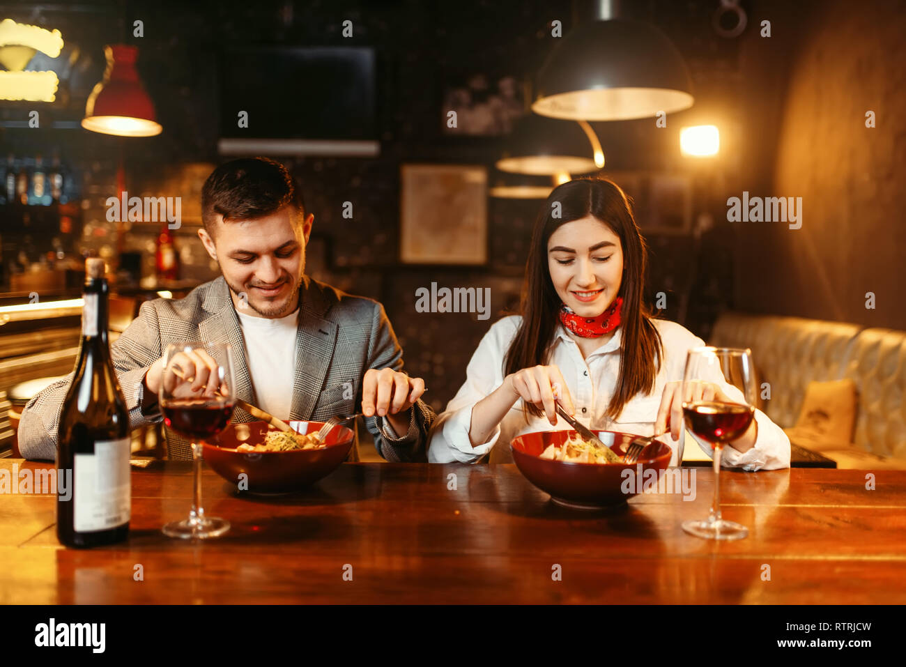 Love couple flirting at wooden bar counter, romantic dinner with paste ...