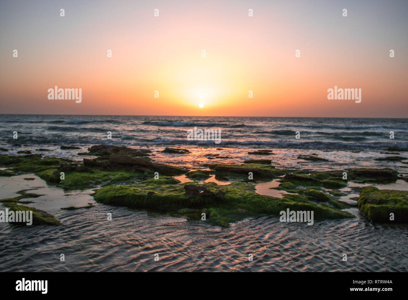 Beach in Tel Aviv, Israel during sunset. warm sun and calm waver coming ...