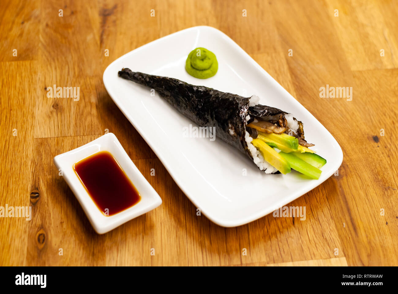 Side view Side view of homemade vegan Temaki-Sushi filled with avocado ...