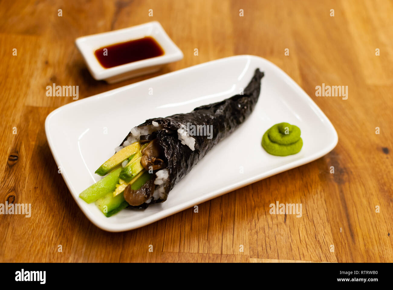 Side view Side view of homemade vegan Temaki-Sushi filled with avocado ...