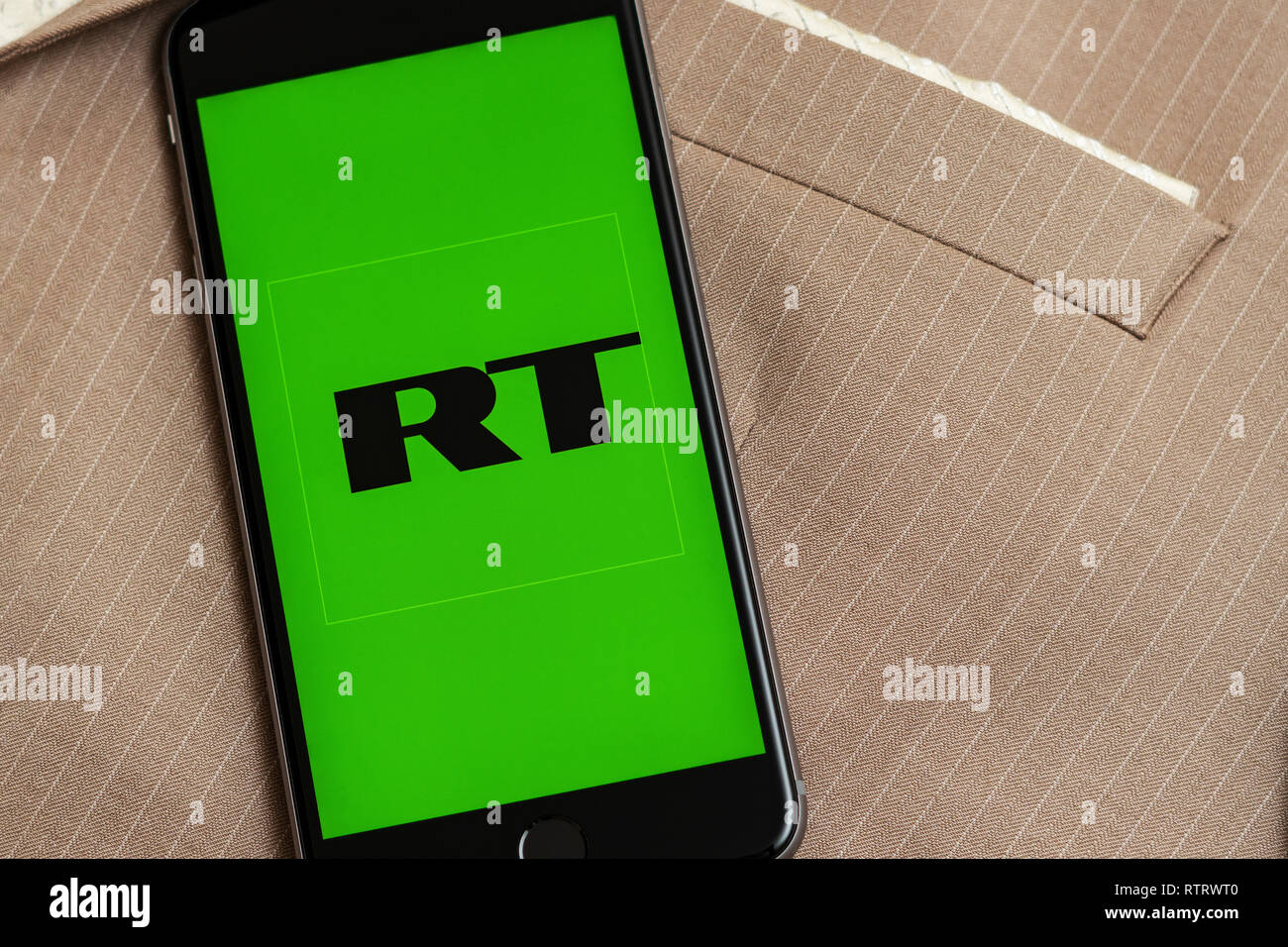 Black phone with logo of news media Russia Today (RT) on the screen ...