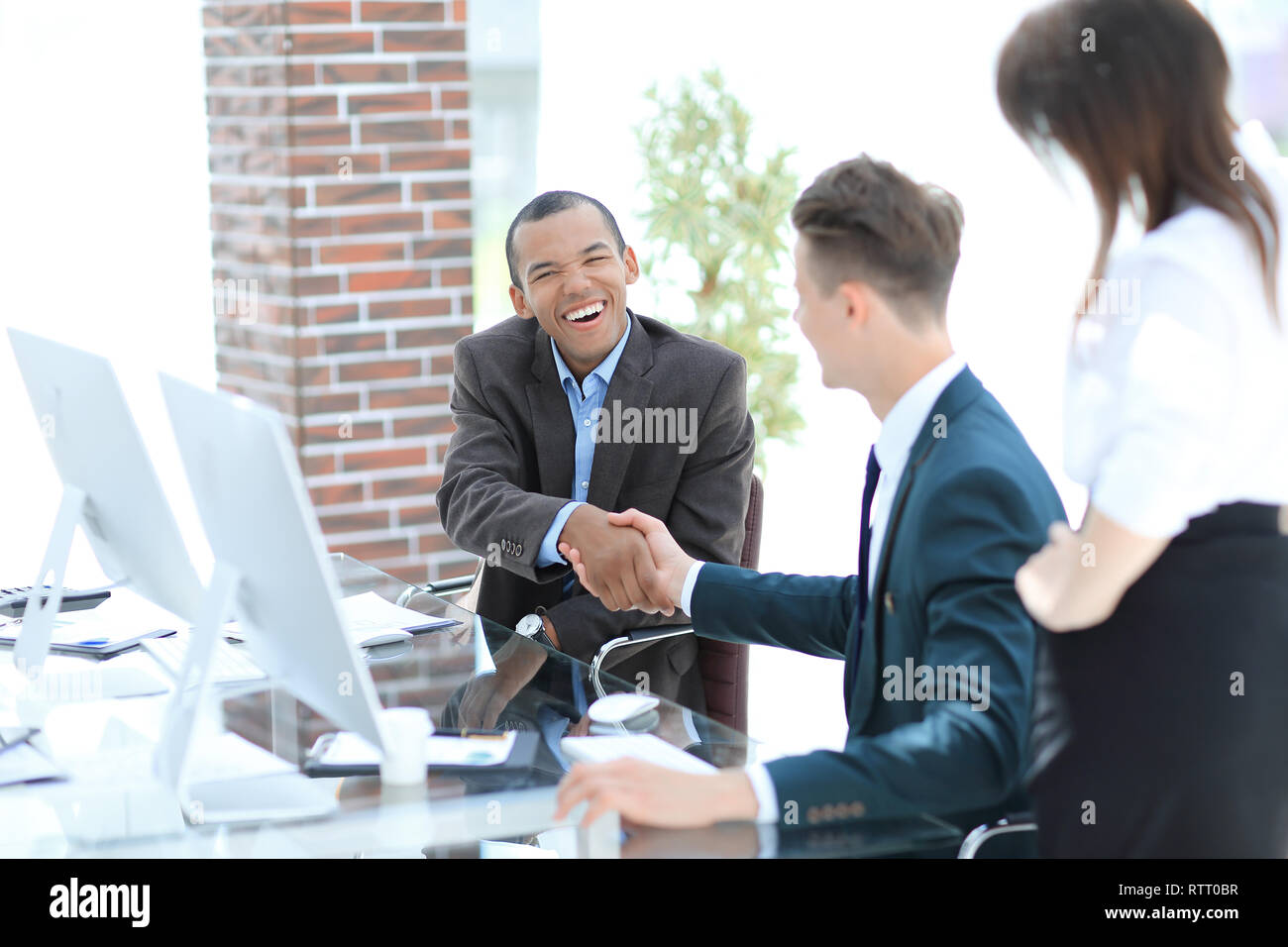 handshake international business partners on a Desk Stock Photo - Alamy