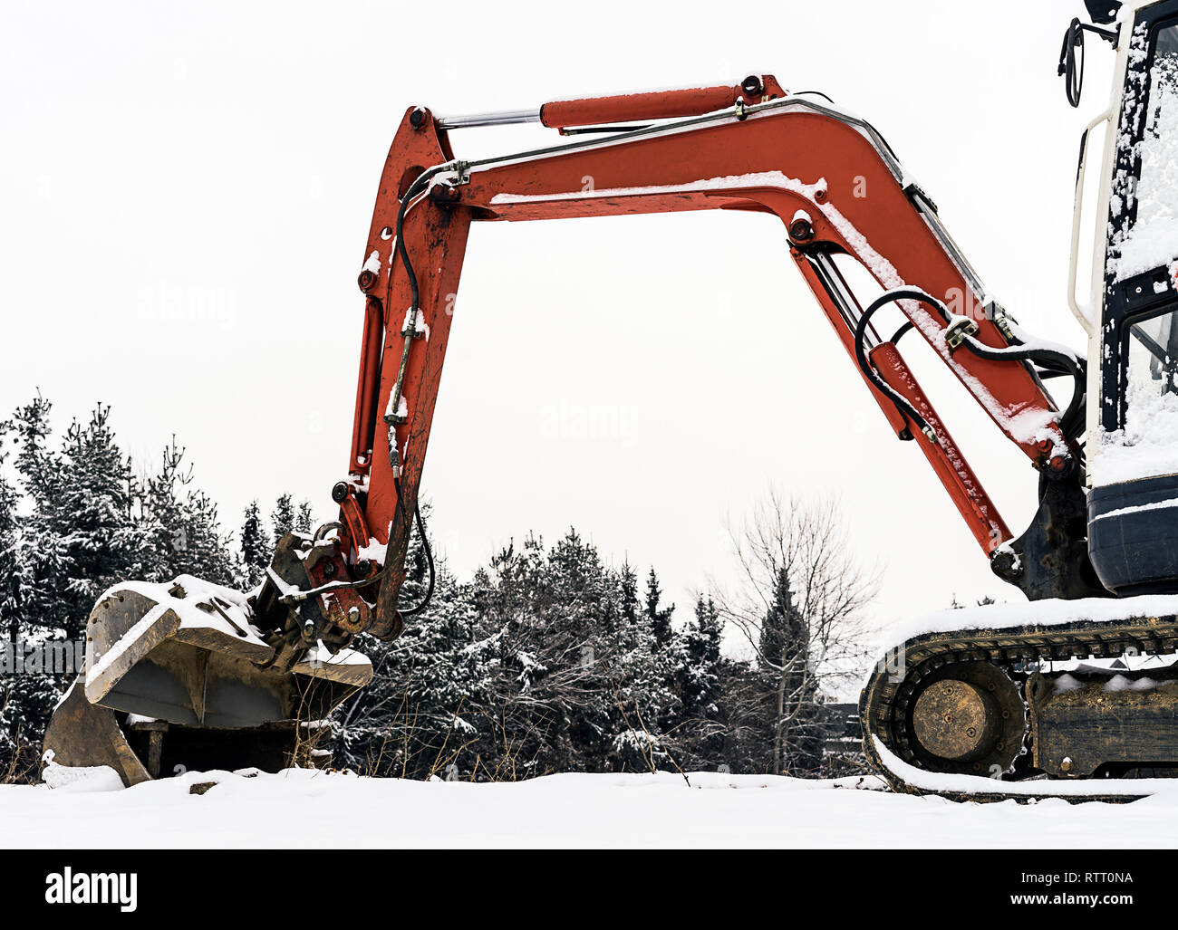 Small excavator machine covered with some snow in winter time Stock ...