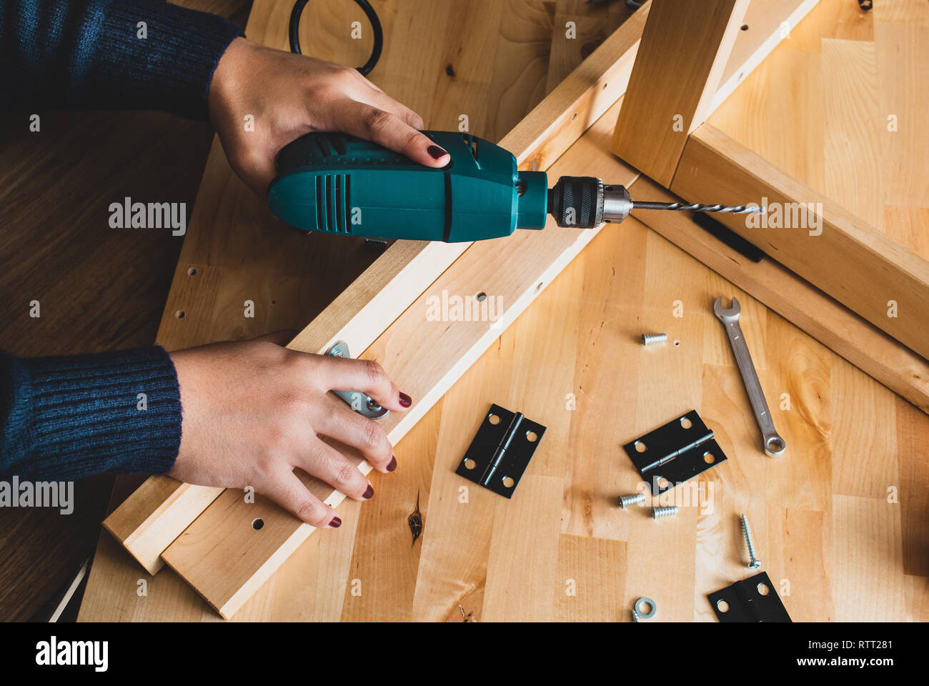 Woman assembly wooden furniture,fixing or repairing house with drill ...