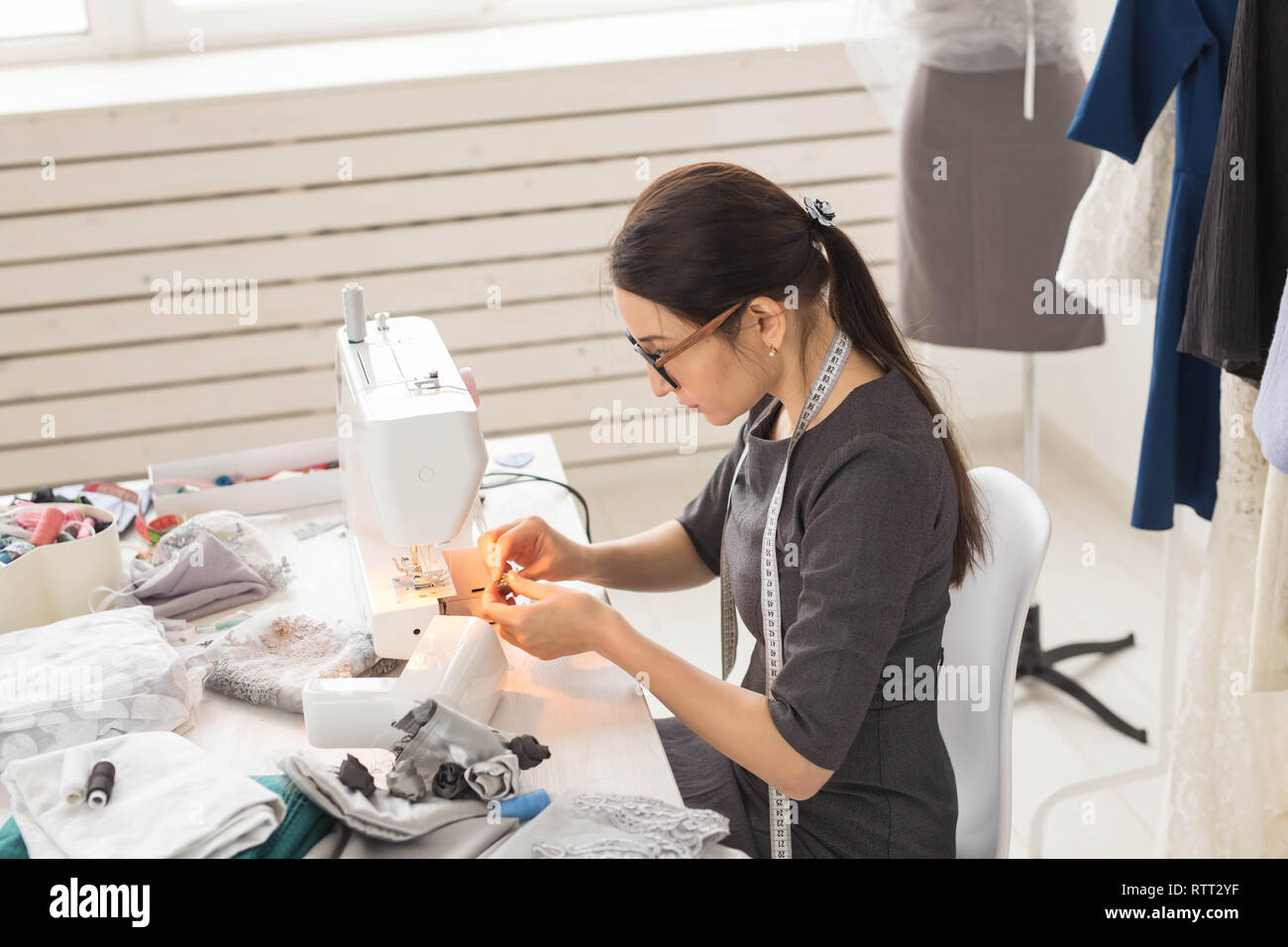 Dressmaker, tailor and seamstress concept - young fashion designer ...