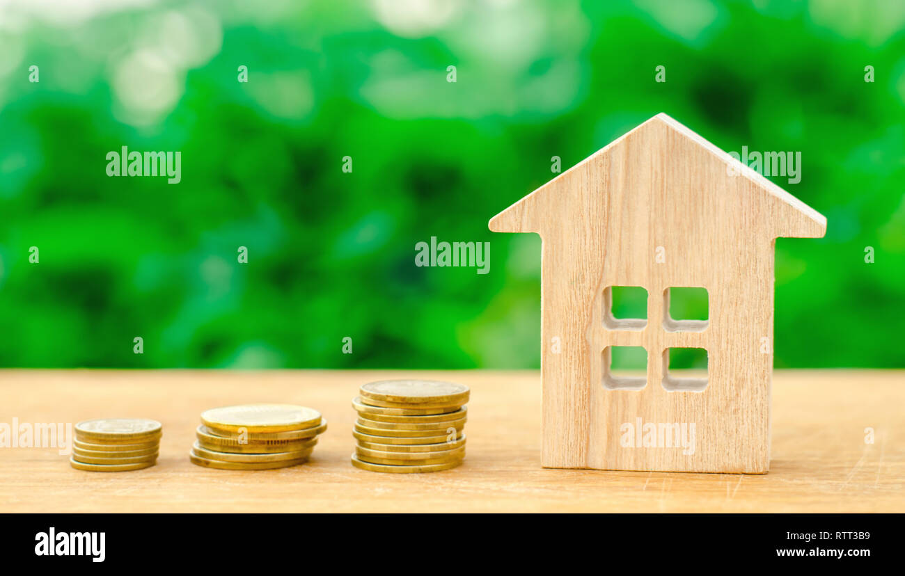 Stacks of coins and a wooden house. The concept of saving money for ...