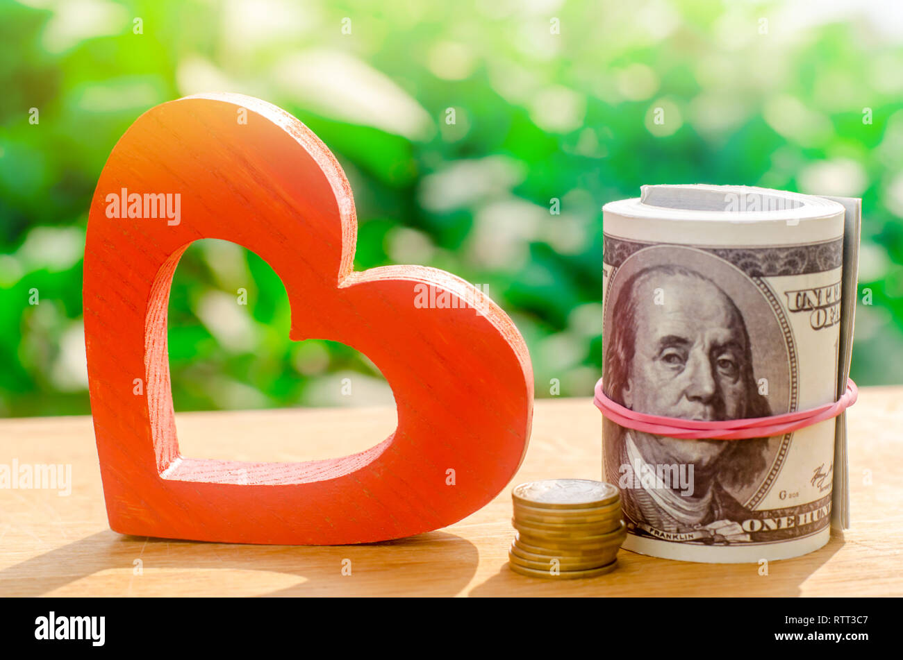 Red wooden heart and money. The concept of saving and accumulation ...