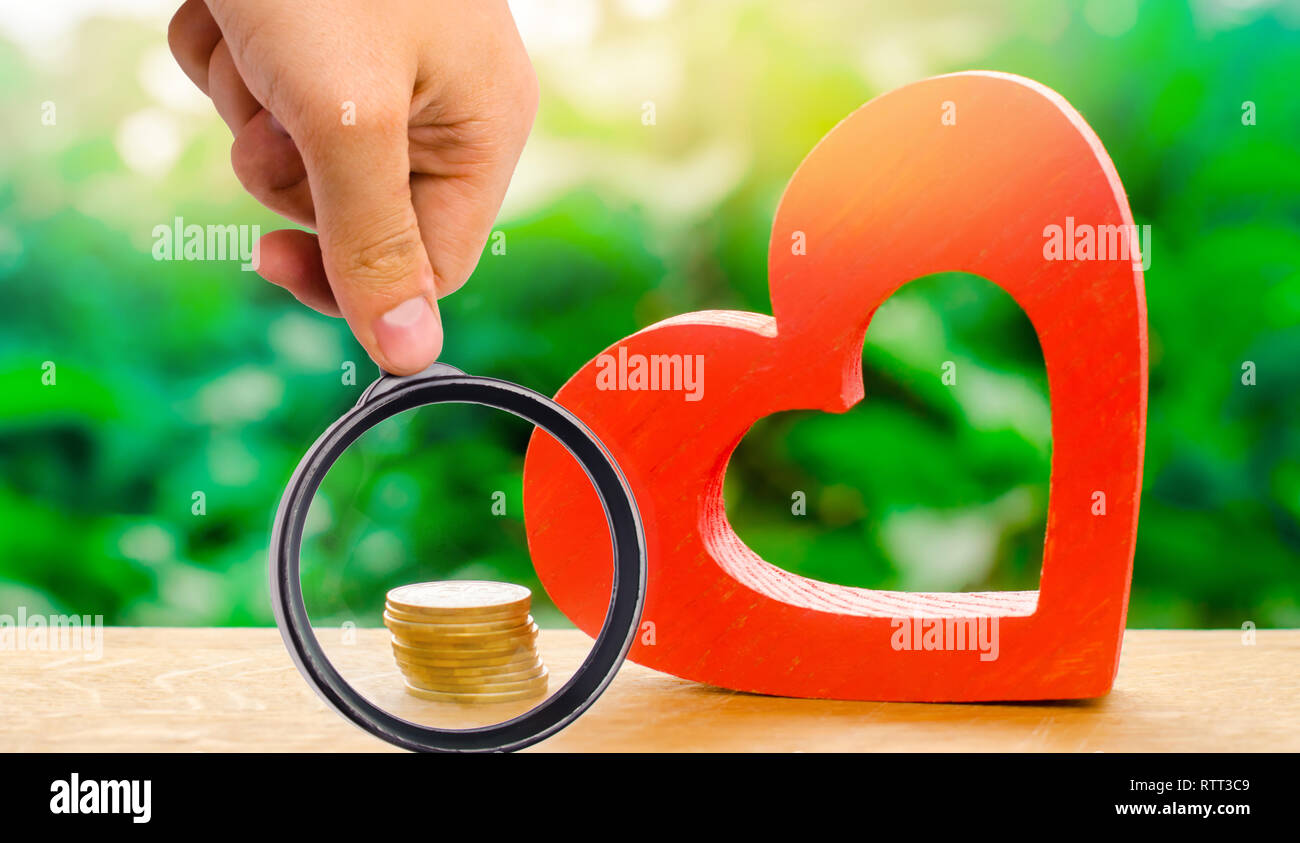 Red wooden heart and money. The concept of saving and accumulation ...
