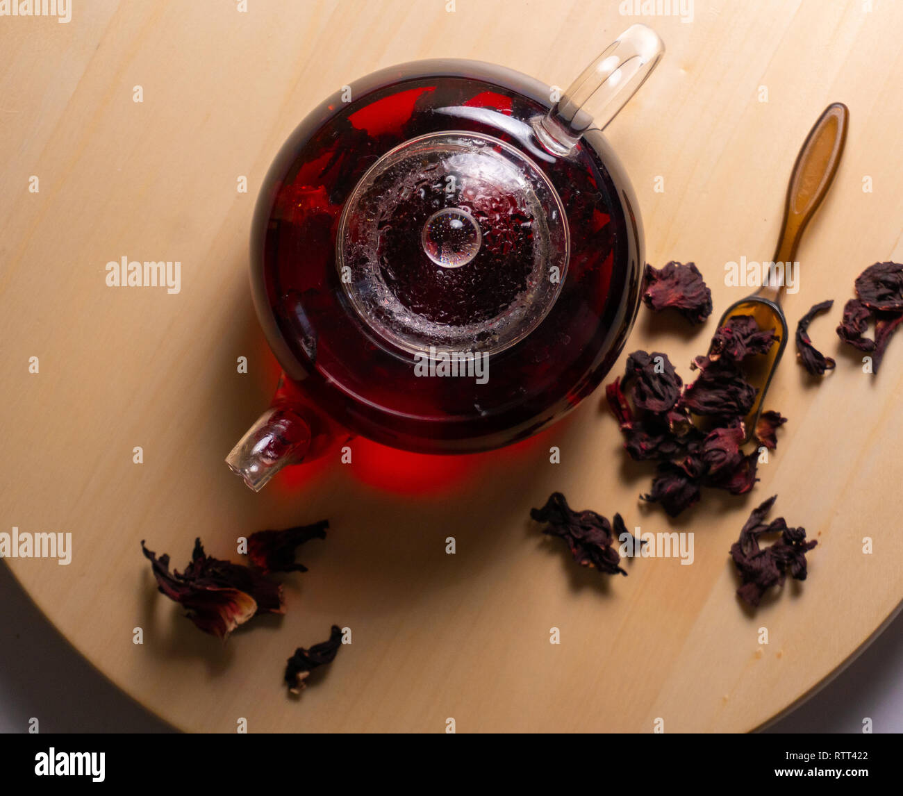 Teapot with red tea and leafs of tea around. Top view on karkade tea ...