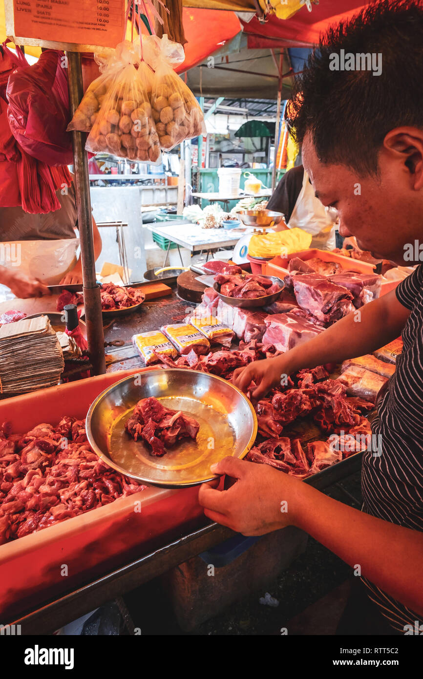KUALA LUMPUR / MALAYSIA / JUNE 2014: Selling meat in the Pudu street ...