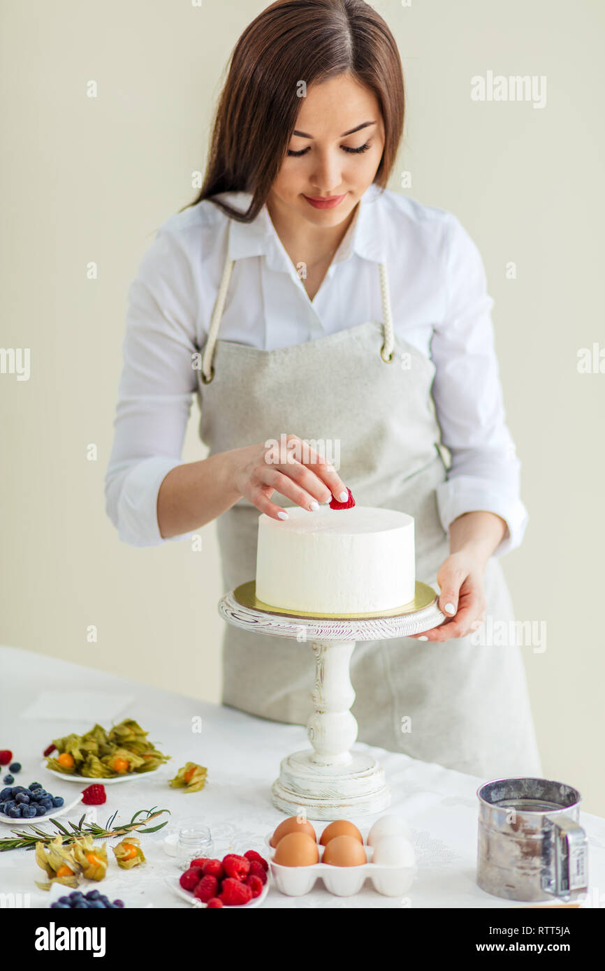 female chef preparing a sweet cake with raspberries, close up photo ...