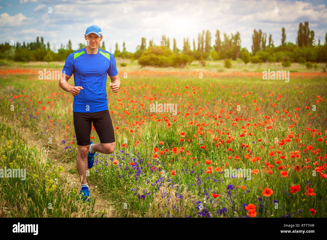 Young man running on poppy field in summer. Sport. Healthy lifestyle ...