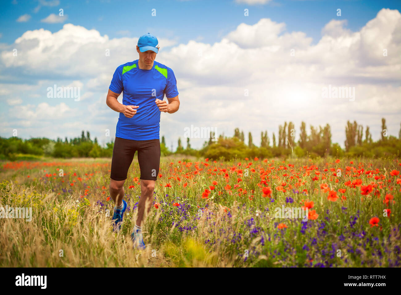 Young man running on poppy field in summer. Sport. Healthy lifestyle ...