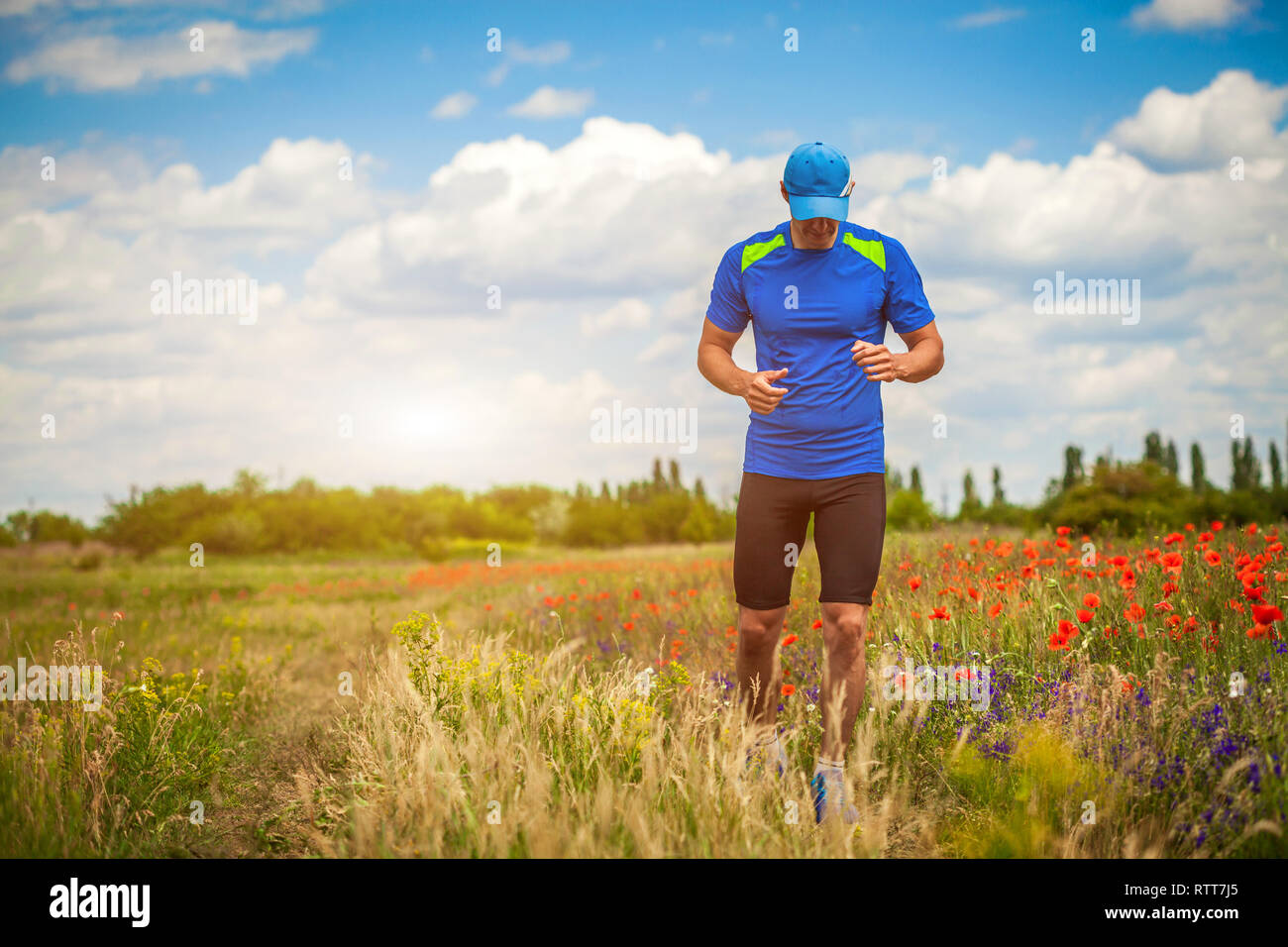 Young man running on poppy field in summer. Sport. Healthy lifestyle ...