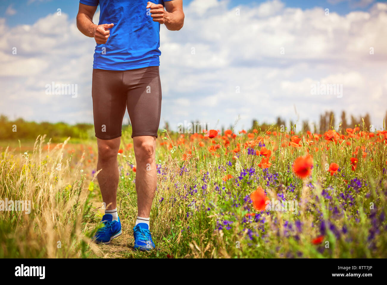 Young man running on poppy field in summer. Sport. Healthy lifestyle ...