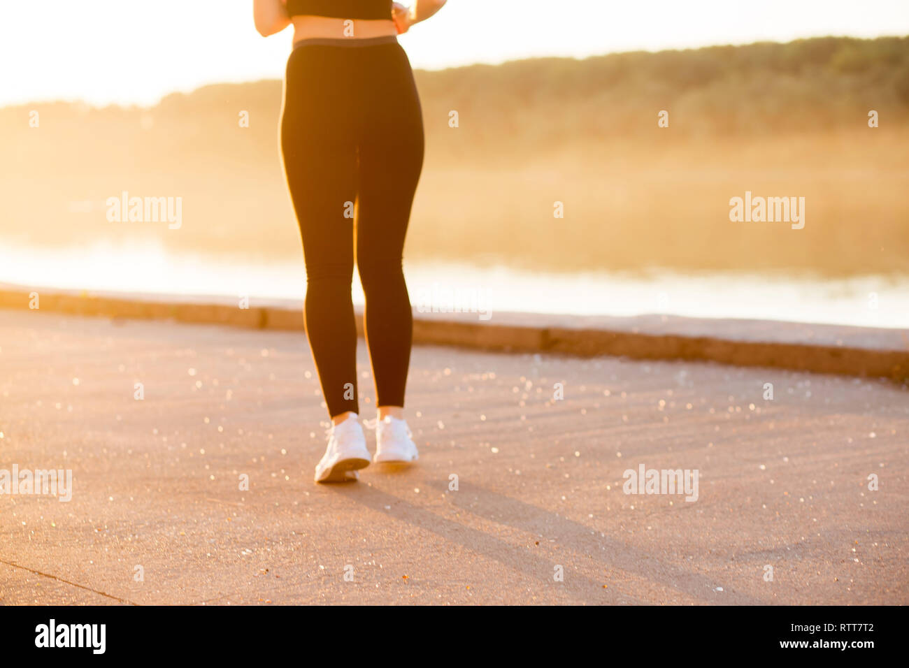 Girl runs around at sunset. Cropped photos of feet in white sneakers ...