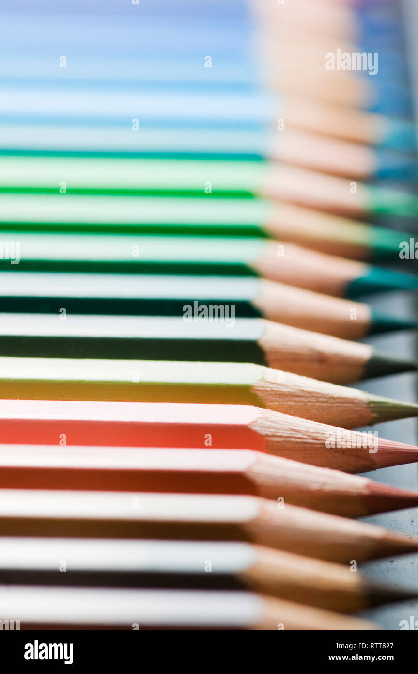 Low angle close-up of parallel horizontal colored pencils on white ...