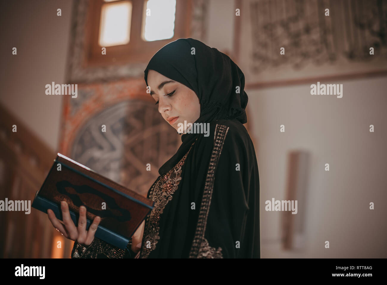 Young beautiful girl reading a holy book of muslim Quran Stock Photo ...