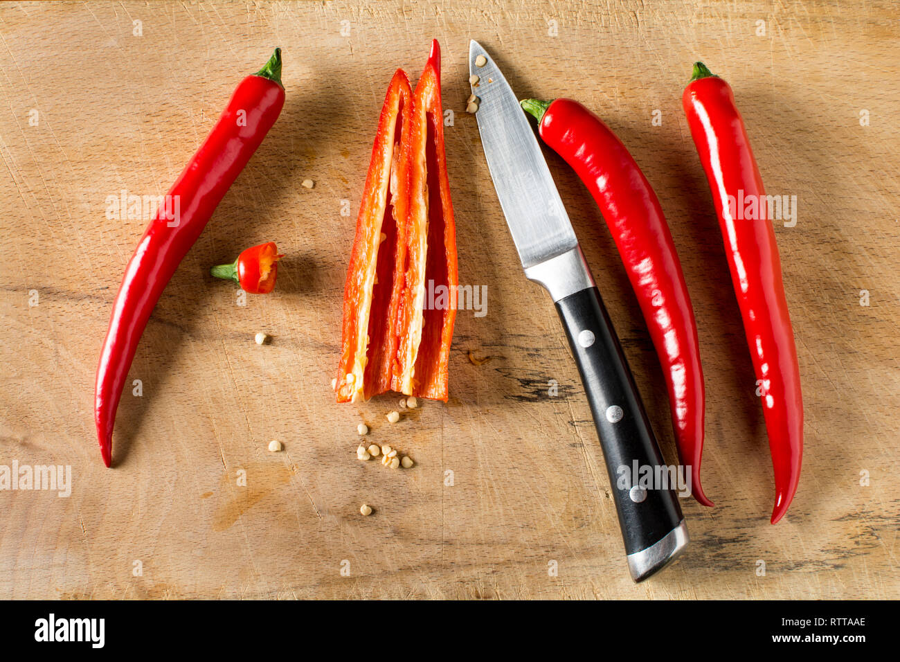 Deseeding Red hot chilli peppers on a carving board with knife Stock ...