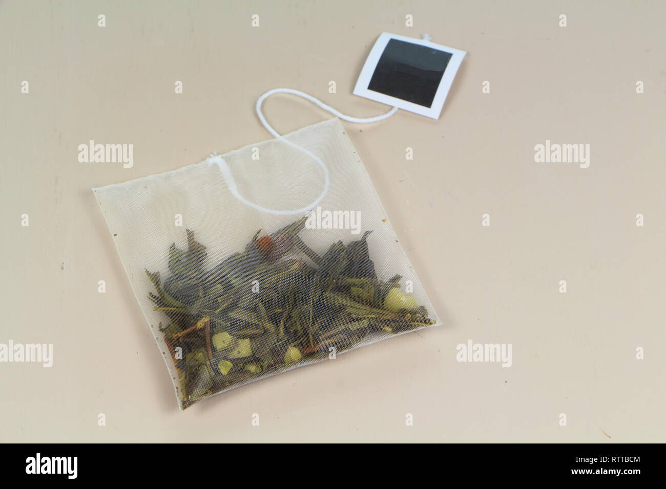 Fabric tea bag of flavored green tea with a label Stock Photo - Alamy