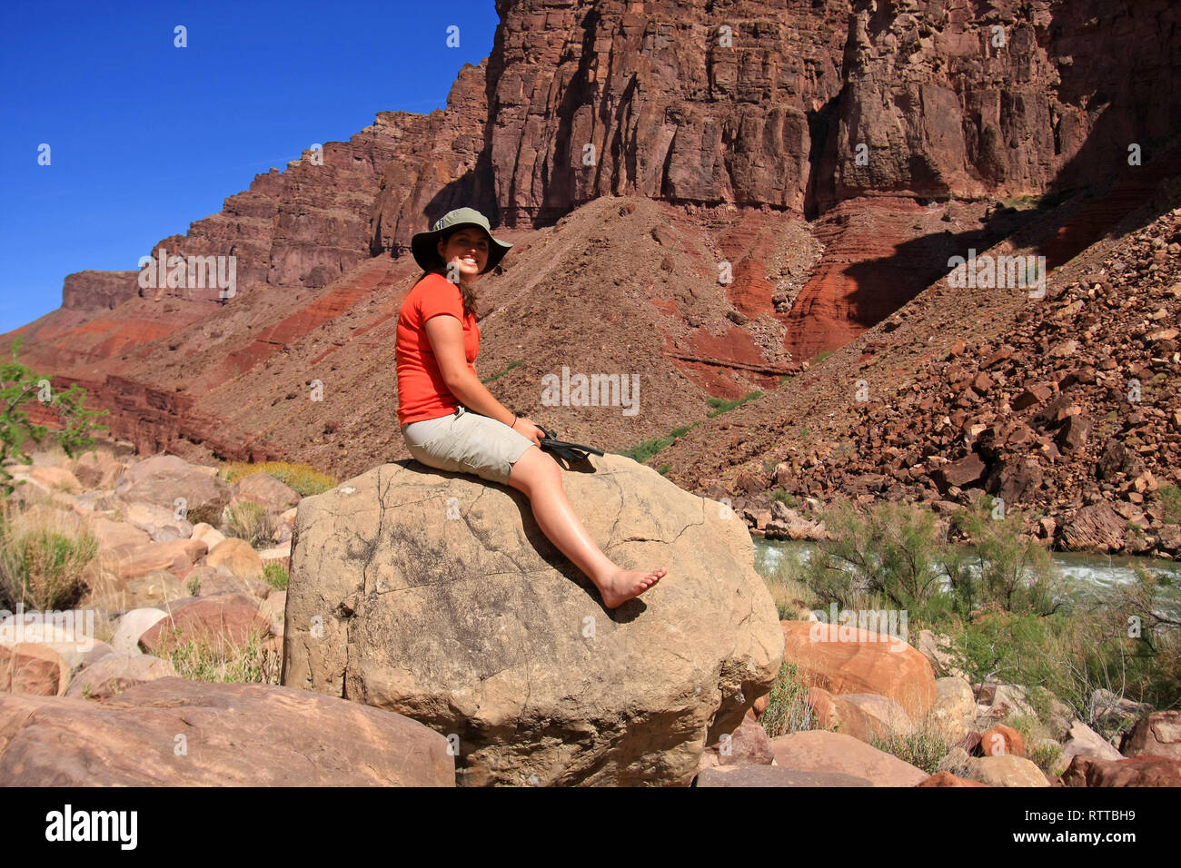 Young woman backpacker explores the boulder fields near Hance Rapids in ...