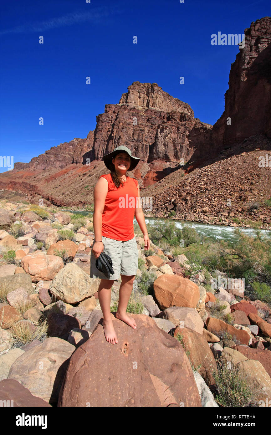 Young woman backpacker explores the boulder fields near Hance Rapids in ...