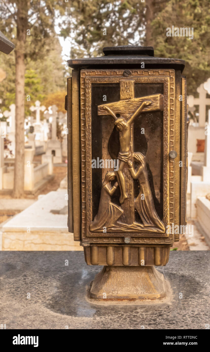 Crucifixion scene on a brass lamp in a cemetery. Closeup shot with a diffused background Stock ...