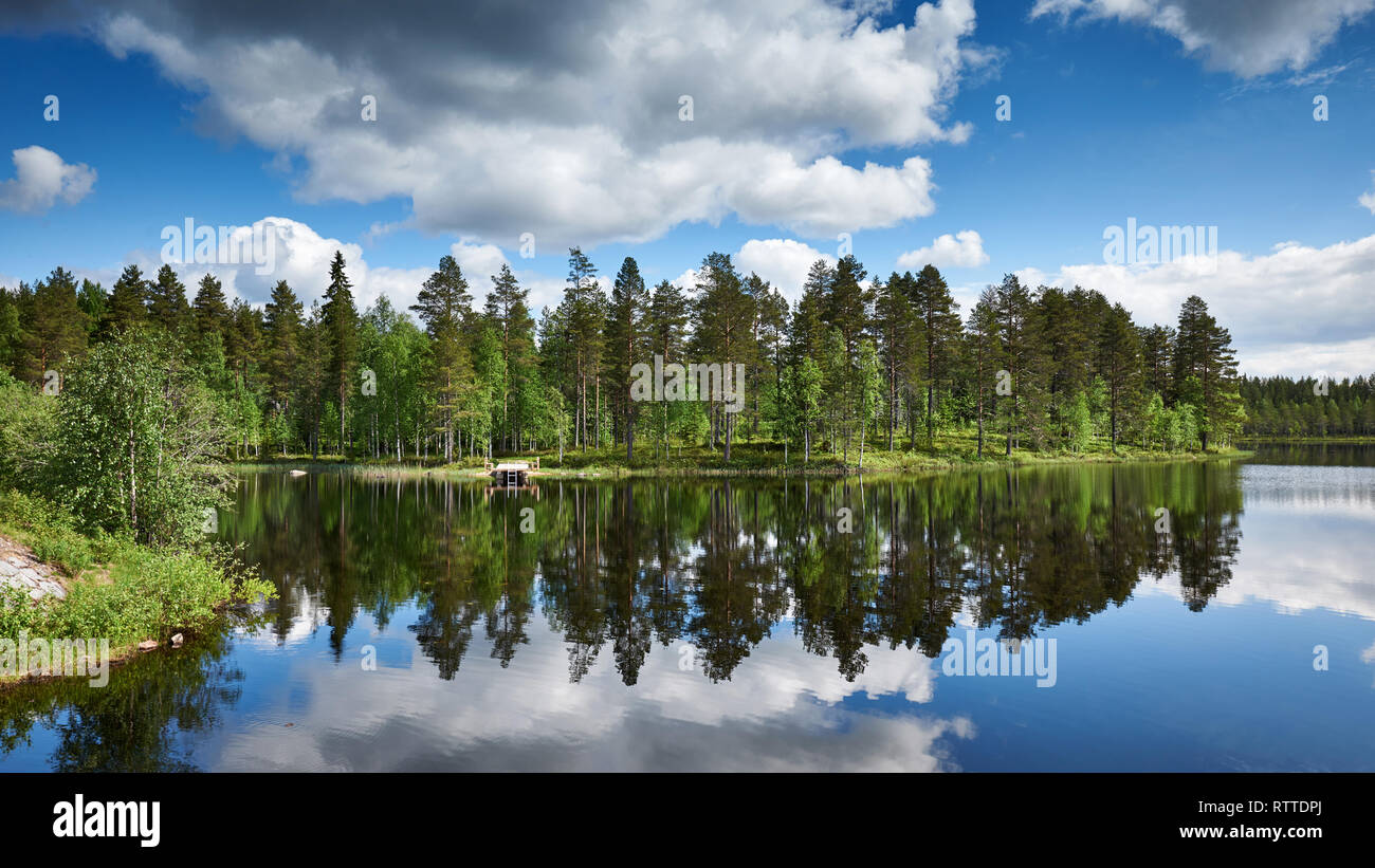 Relaxing Finnish landscape, with lake, a little pier, forest, trees ...