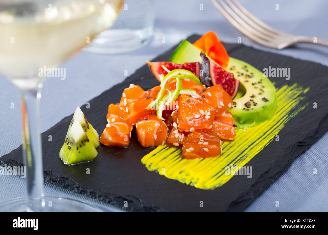 Fish tartare of raw tuna with slice of avocado and spicy mango sauce on ...